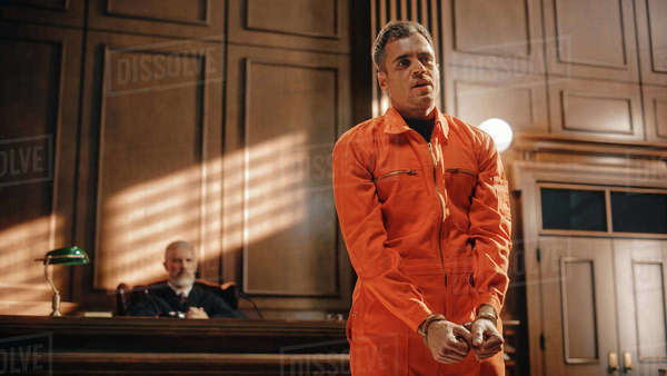 Male Criminal in Orange Jumpsuit Giving Testimony to Judge - Royalty ...