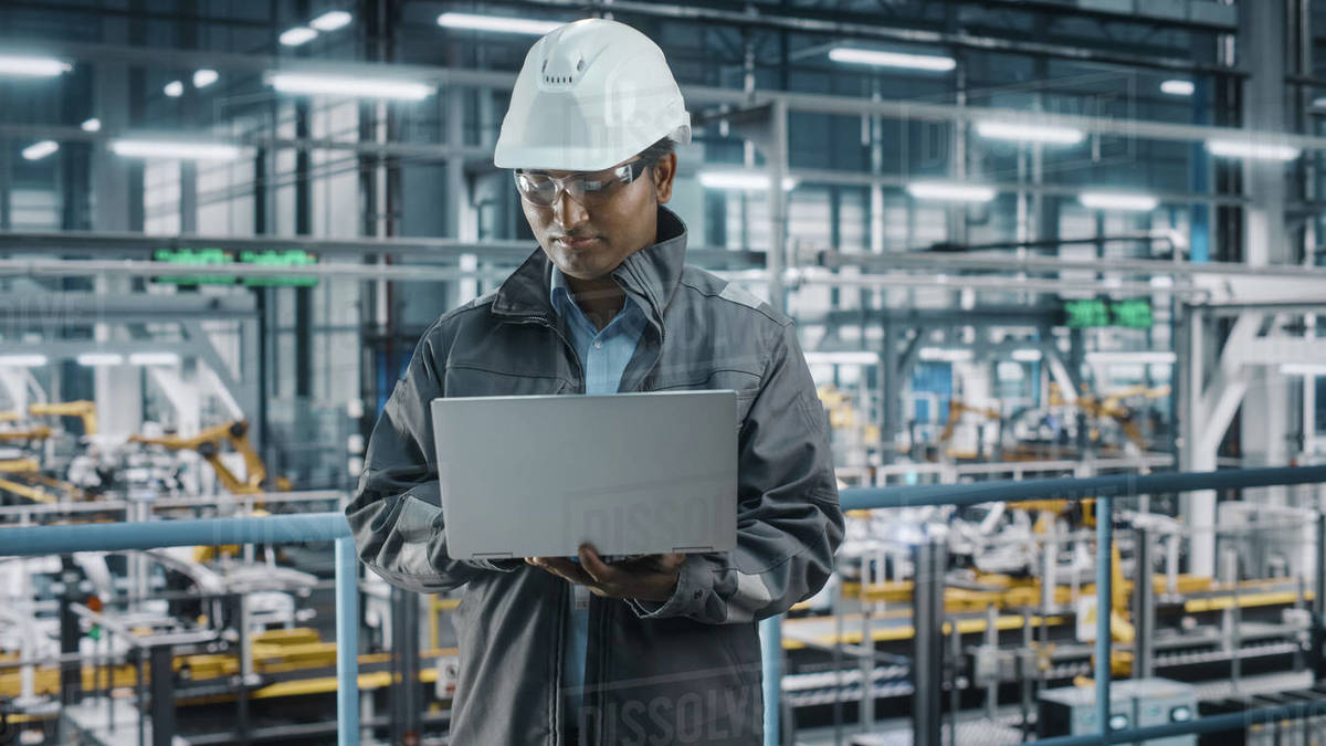 Portrait of Automotive Industry Engineer in Safety Uniform Using Laptop ...