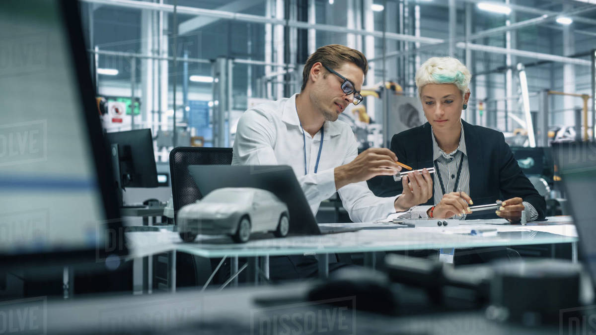Two Young Automotive Engineers Working in Office at Car Factory ...