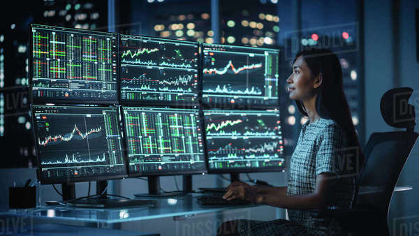 Financial Analyst Working on a Computer with Multi-Monitor Workstation ...