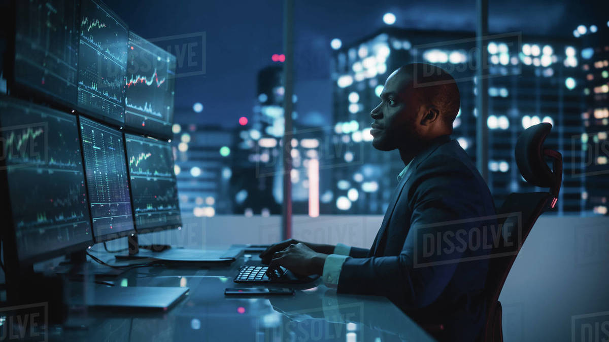 Financial Analyst Working on Computer with Multi-Monitor Workstation ...