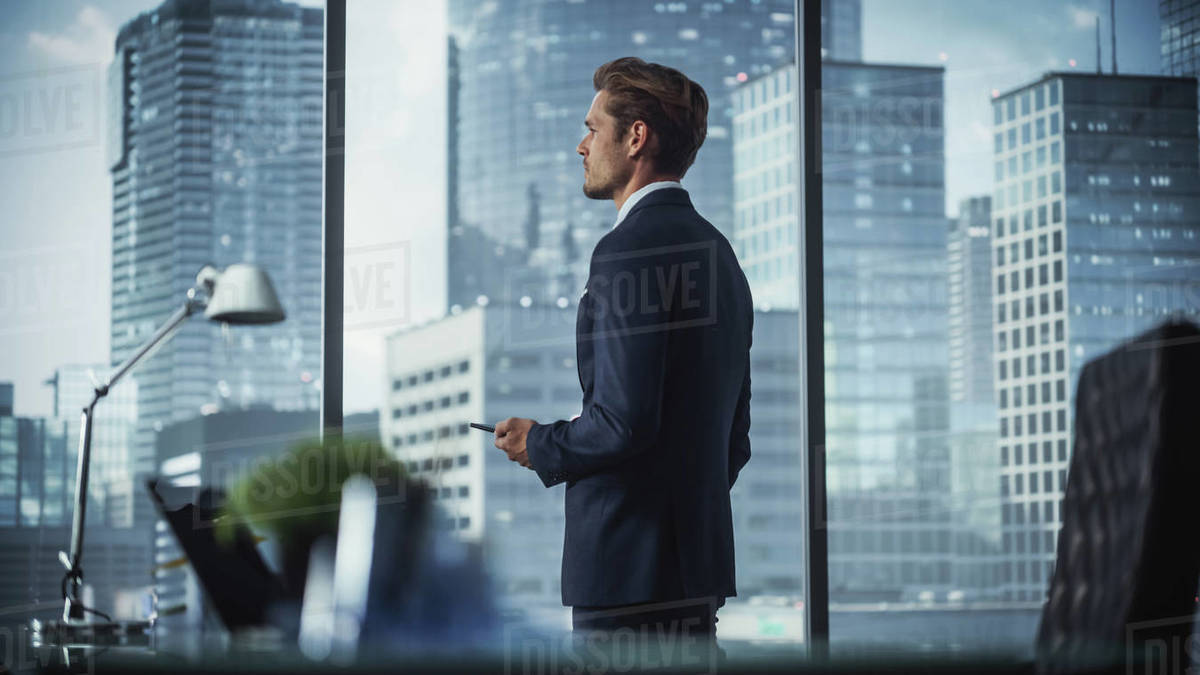 Businessman Standing Next to a Window in a Modern Office - Royalty-free ...