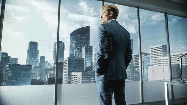 Businessman Standing Next to a Window in a Modern Office - Royalty-free ...