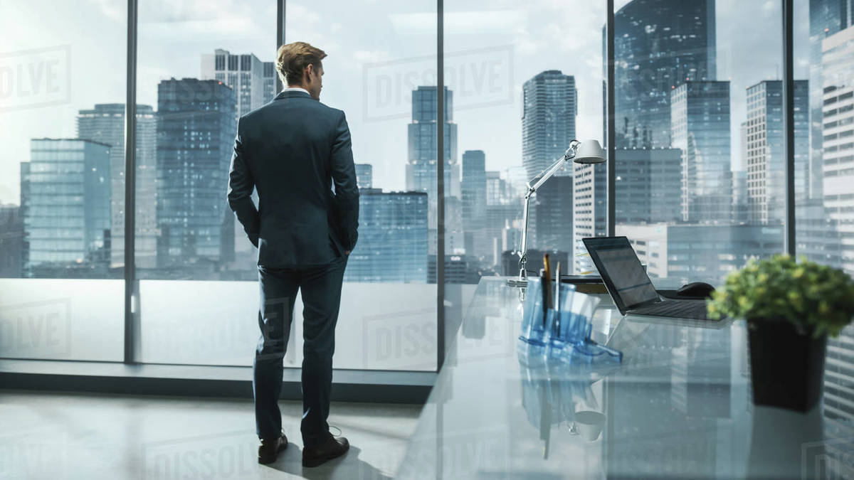 Businessman Standing Next to a Window in a Modern Office - Royalty-free ...