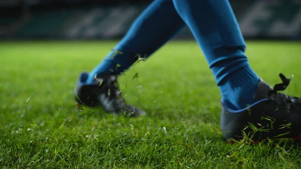 Close-up of a Leg in a Boot Kicking Football Ball. Professional Soccer ...