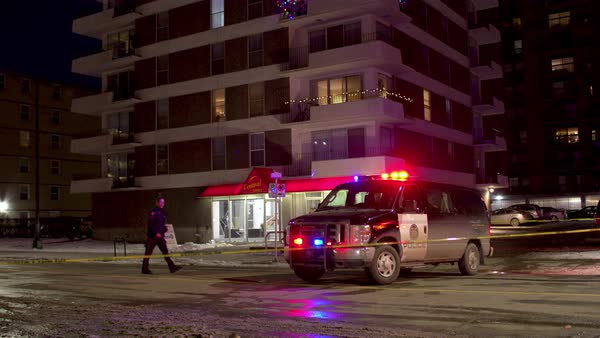 Wide shot of a police officer sitting in police van at night, Calgary ...
