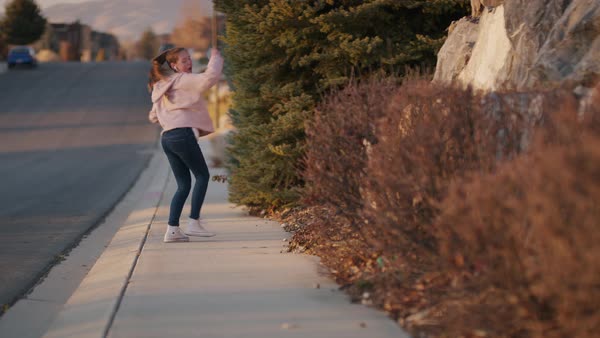 Girl dancing to music on cell phone on neighborhood sidewalk - 4K ...