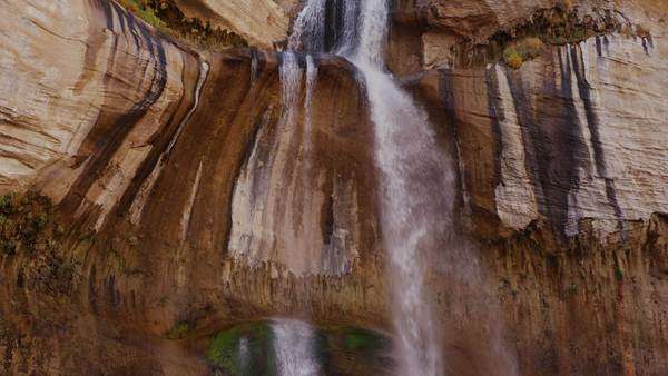Panning medium shot of cliff wall at Lower Calf Creek Falls, Utah ...