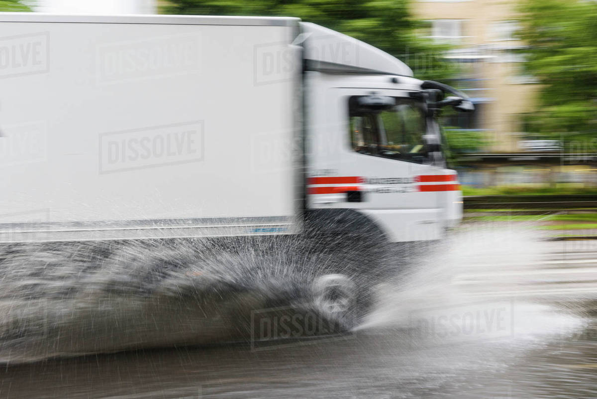 Lorry splashing water on road - Stock Photo - Dissolve