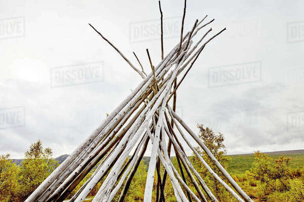 Teepee-shaped log structure - Stock Photo - Dissolve