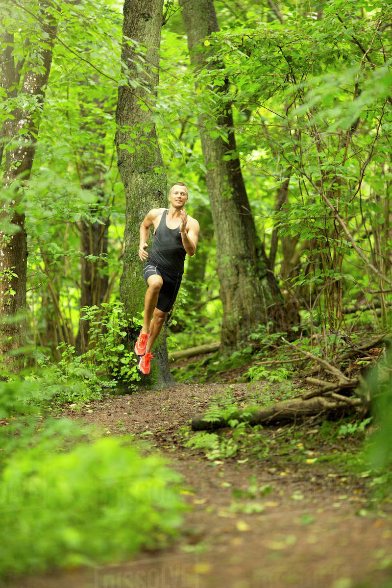 Man running in forest - Stock Photo - Dissolve