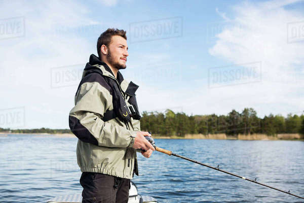 Young man fishing - Royalty-free Stock Photo | Dissolve