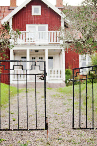 Open gate, wooden house on background - Stock Photo - Dissolve