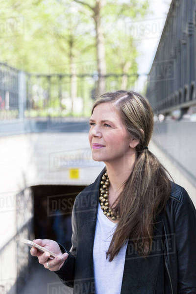 Woman holding cell phone - Royalty-free Stock Photo | Dissolve