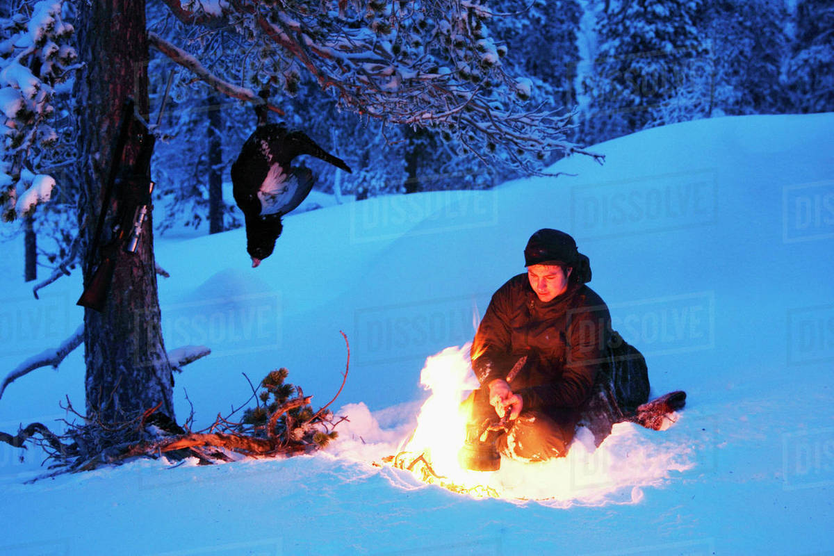 Hunter having fire at dusk - Royalty-free Stock Photo | Dissolve