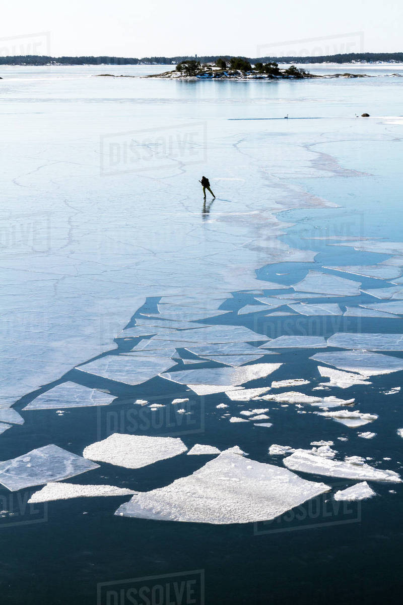 Person ice-skating on frozen water - Royalty-free Stock Photo | Dissolve