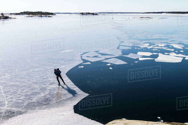 Person ice-skating on frozen water - Royalty-free Stock Photo | Dissolve