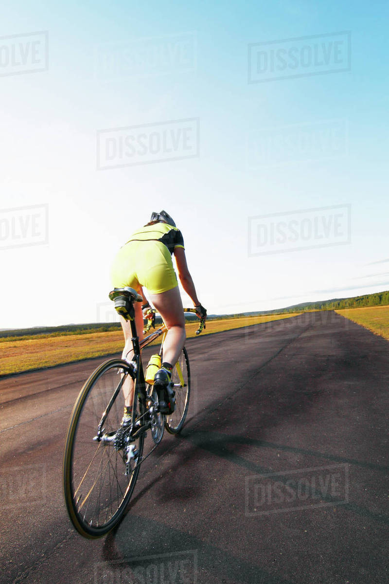 Woman cycling, rear view - Royalty-free Stock Photo | Dissolve