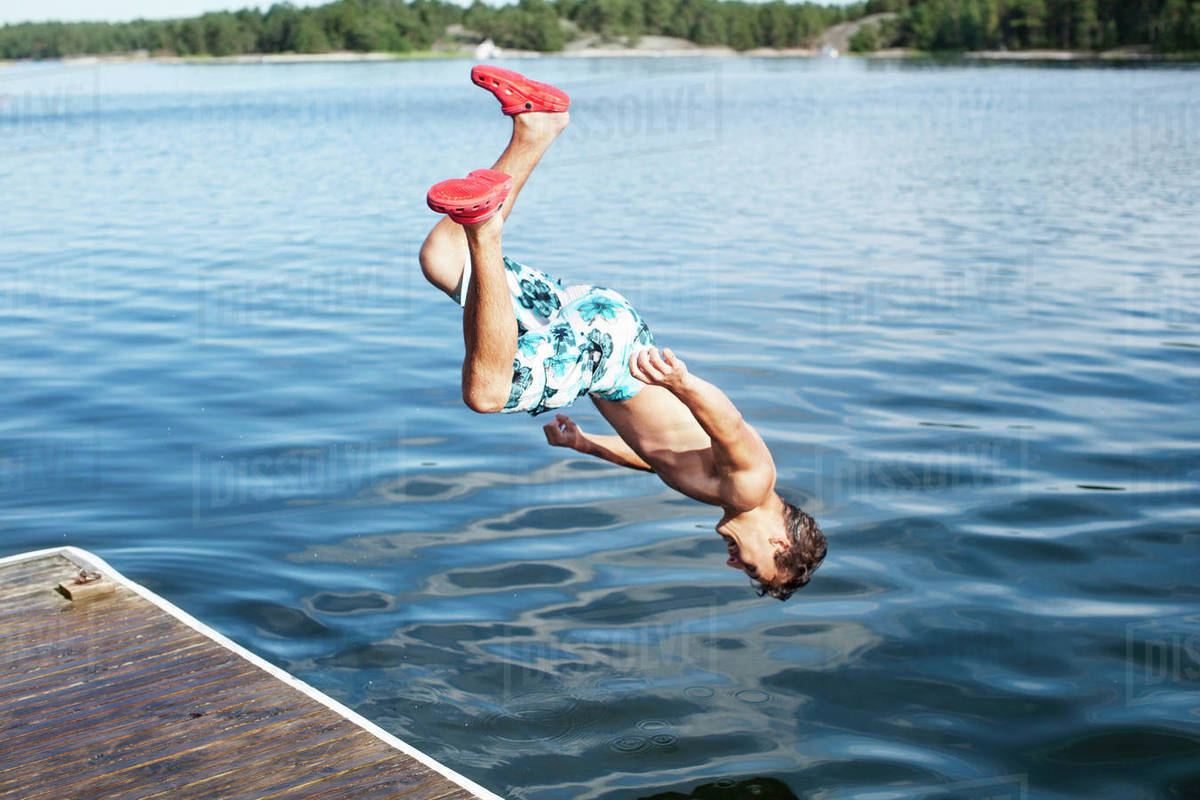 Teenage boy jumping into water - Royalty-free Stock Photo | Dissolve