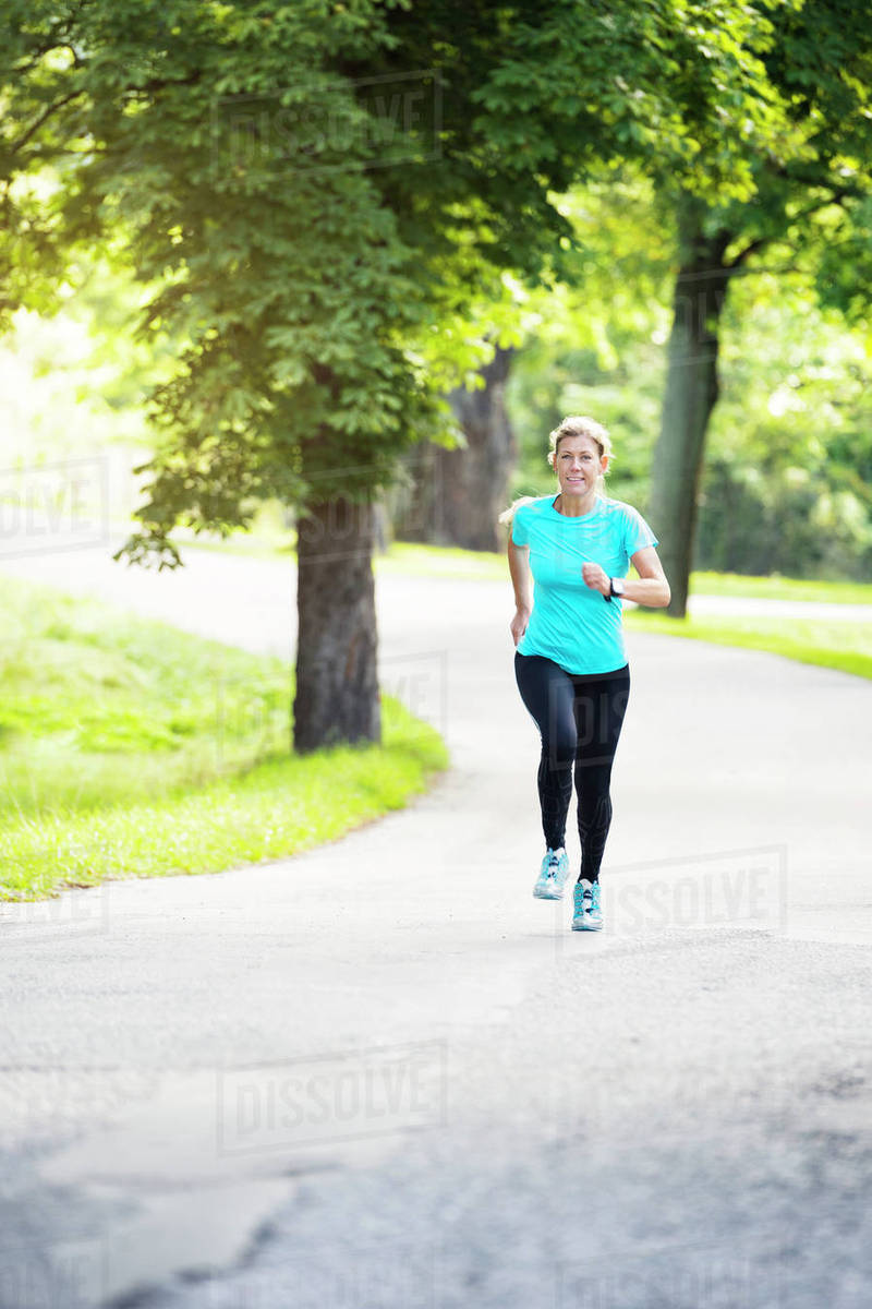 Woman jogging in park - Royalty-free Stock Photo | Dissolve