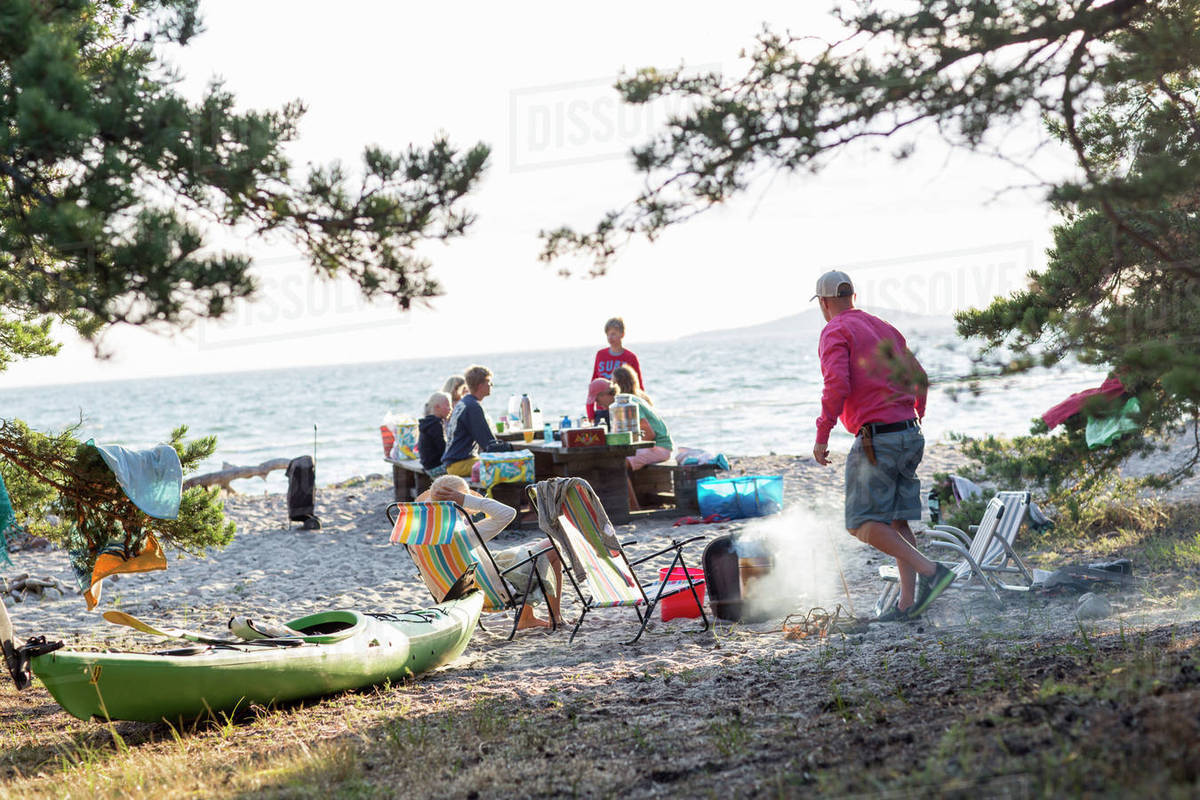 Family having meal on beach - Royalty-free Stock Photo | Dissolve