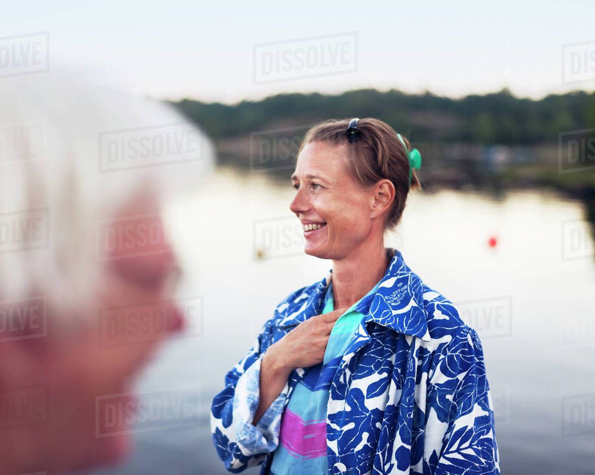 Smiling mid adult woman at water - Royalty-free Stock Photo | Dissolve