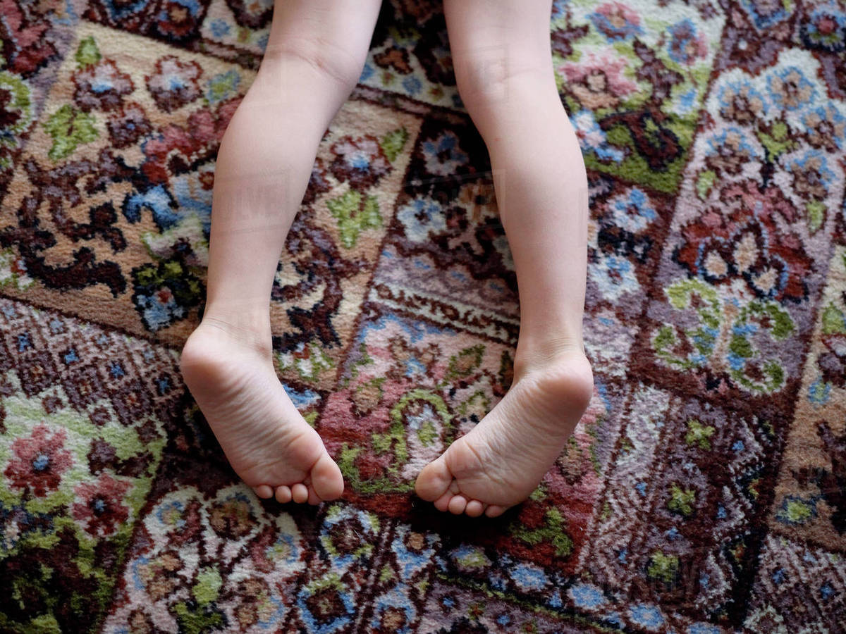 Childs legs on carpet - Stock Photo - Dissolve