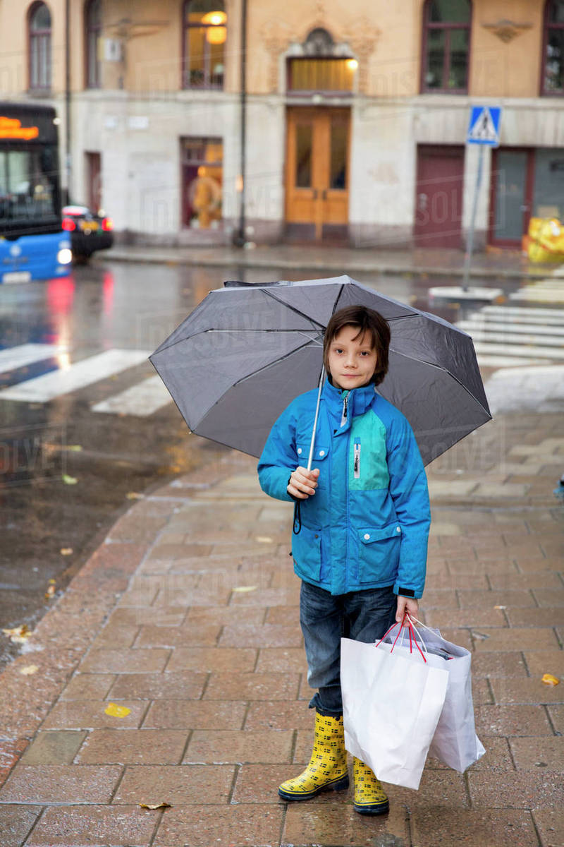 Boy at rain with paper bags - Royalty-free Stock Photo | Dissolve