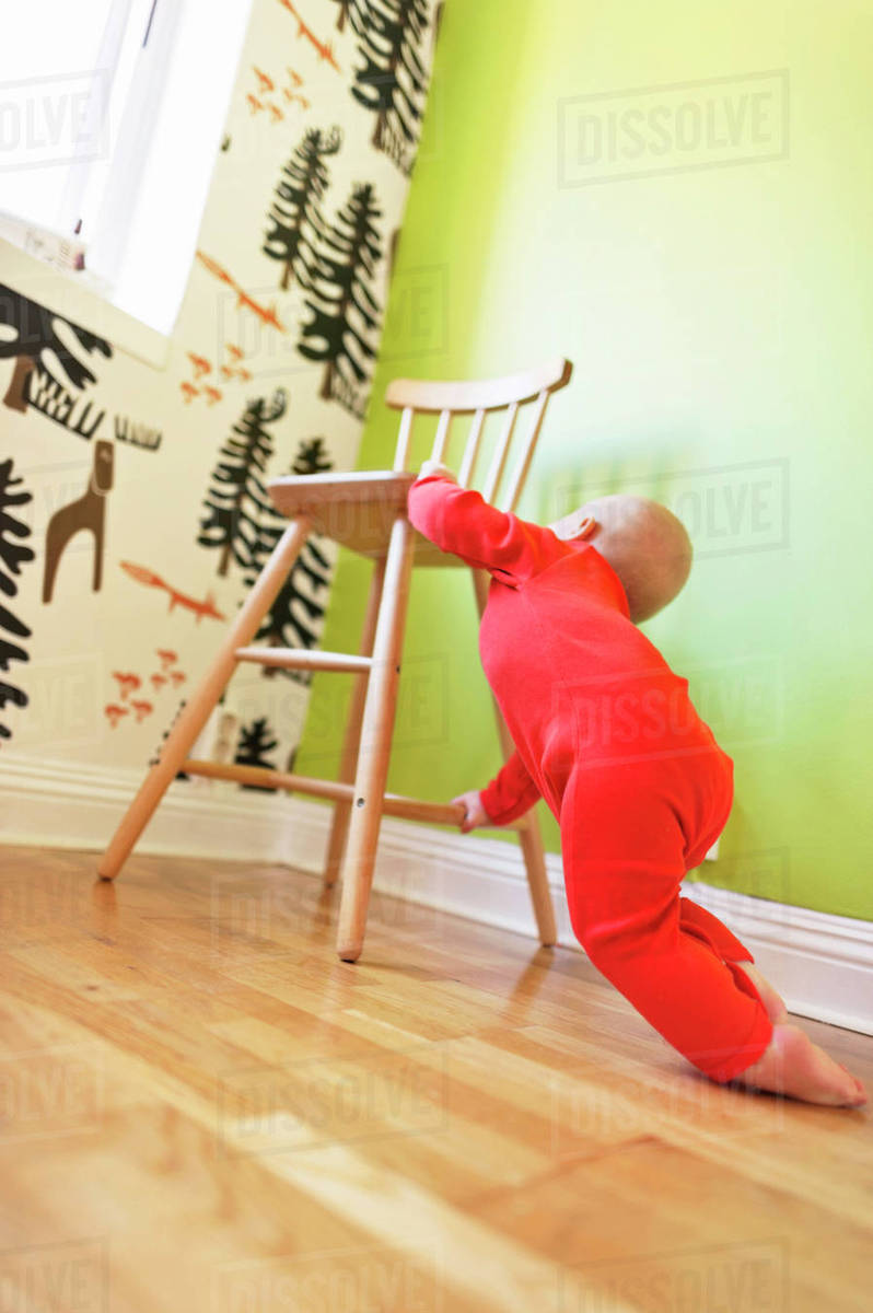 Baby climbing on chair - Stock Photo - Dissolve