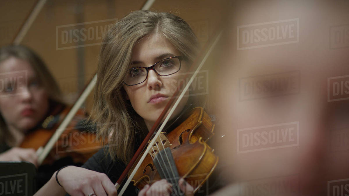 Selective focus view of serious teenage girl musician playing violin in ...