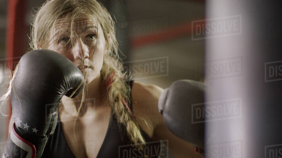 Low angle view of female boxer protecting her face standing in boxing ...