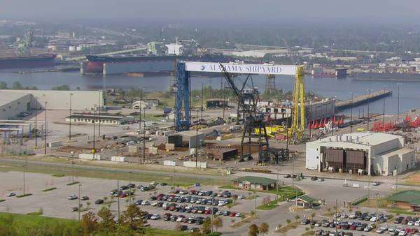 Wide shot POV aerial zoom out zoom in view of Alabama shipyard in Port ...