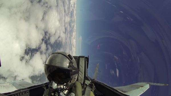 A pilot or passenger is shown flying in a F18 fighter plane, the clouds ...