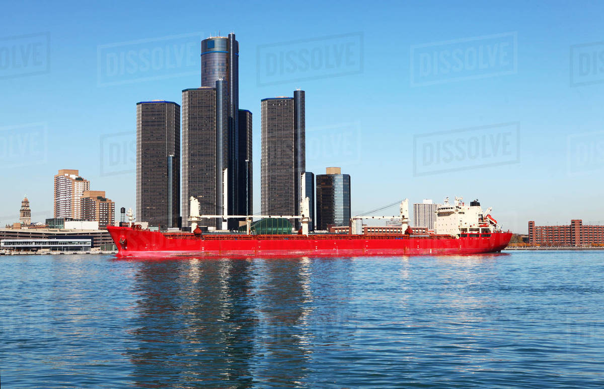 Cargo ship moving in Detroit River with city skyline in background ...