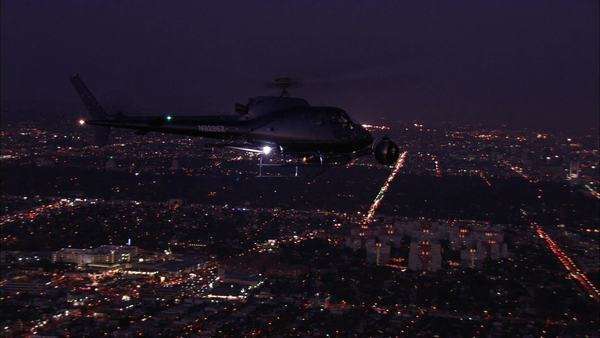 Handheld wide shot of a helicopter flying over a city at night - Stock ...
