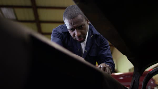 Mechanic working on a classic car engine in garage workshop - Stock ...