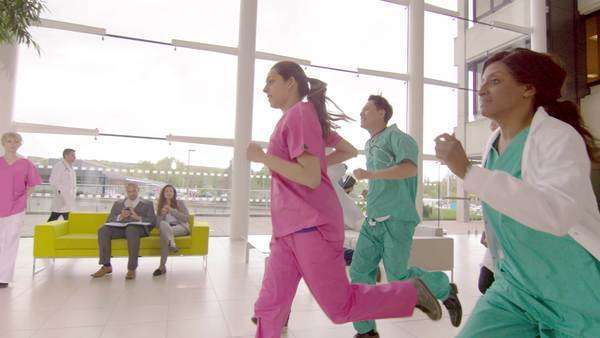 Medical team running through hospital building, responding to an ...