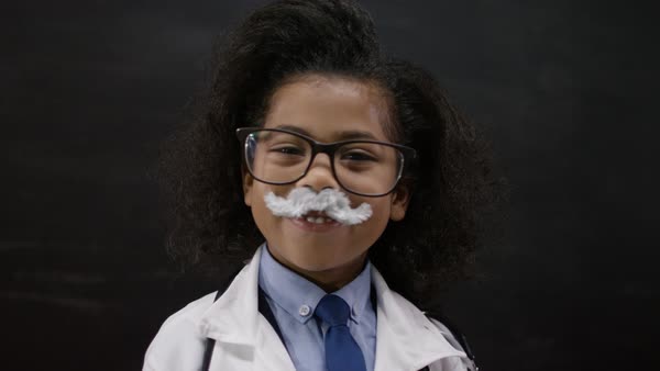 Portrait of happy little scientist with fake mustache writing math ...