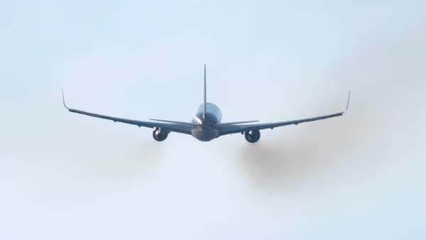 Rear view of a jet plane climbing after takeoff. Airliner lifting into ...