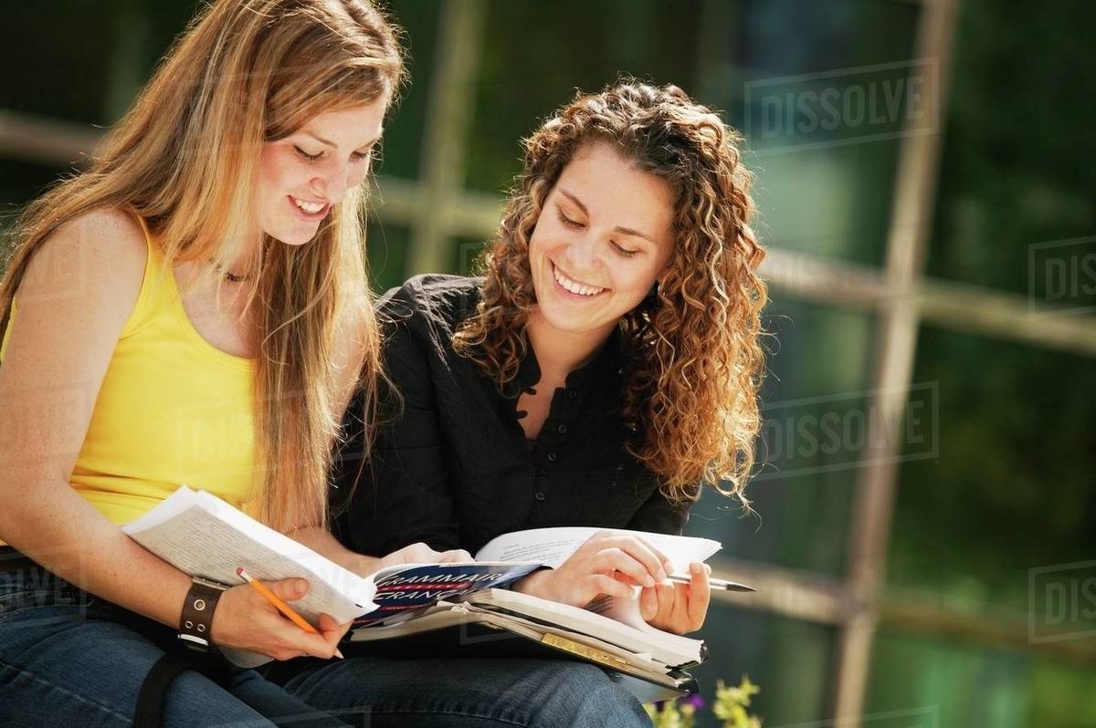 Girls Work Together On Their School Work - Stock Photo - Dissolve