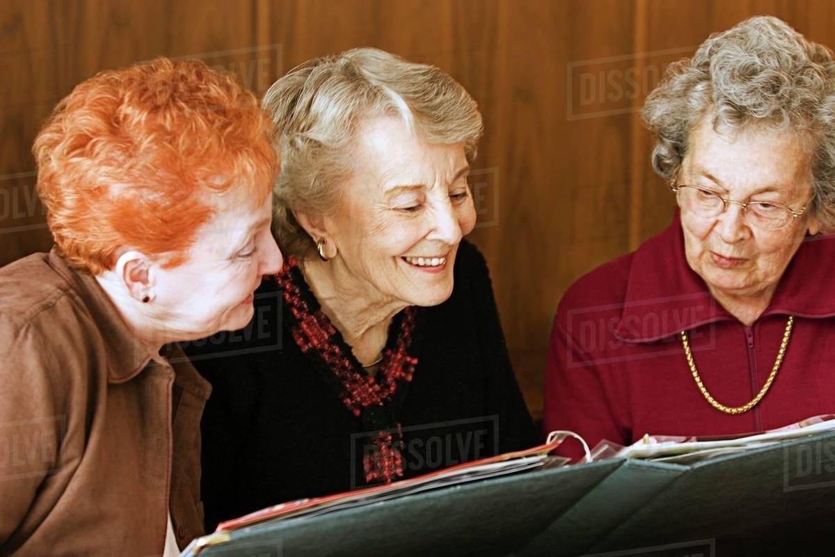 Seniors Reminiscing Over Photo Album - Stock Photo - Dissolve