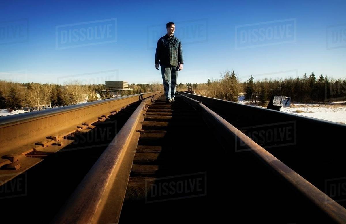 Man Walking Along Railroad Tracks - Royalty-free Stock Photo | Dissolve