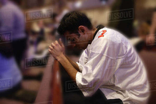 Young Man Praying In Church Pew - Royalty-free Stock Photo | Dissolve