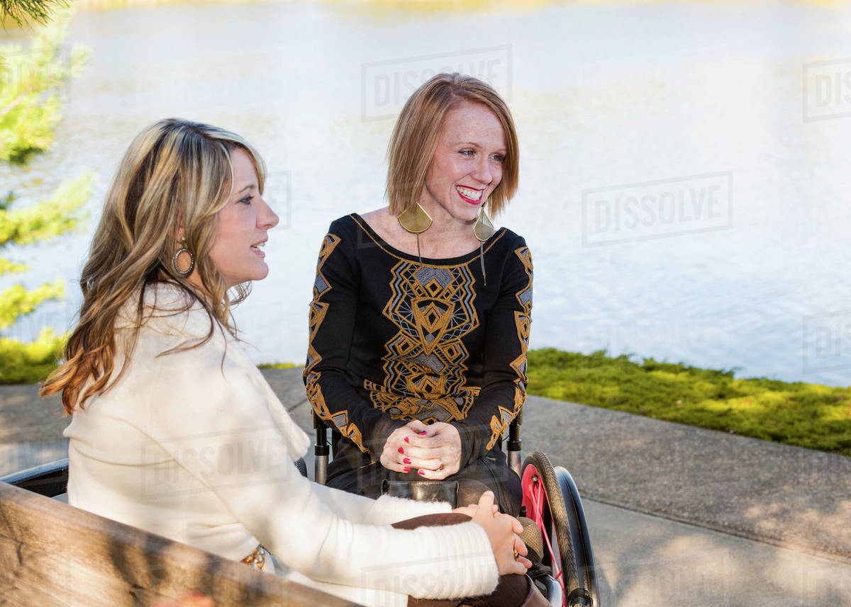Young paraplegic woman and her friend spending quality time together in ...