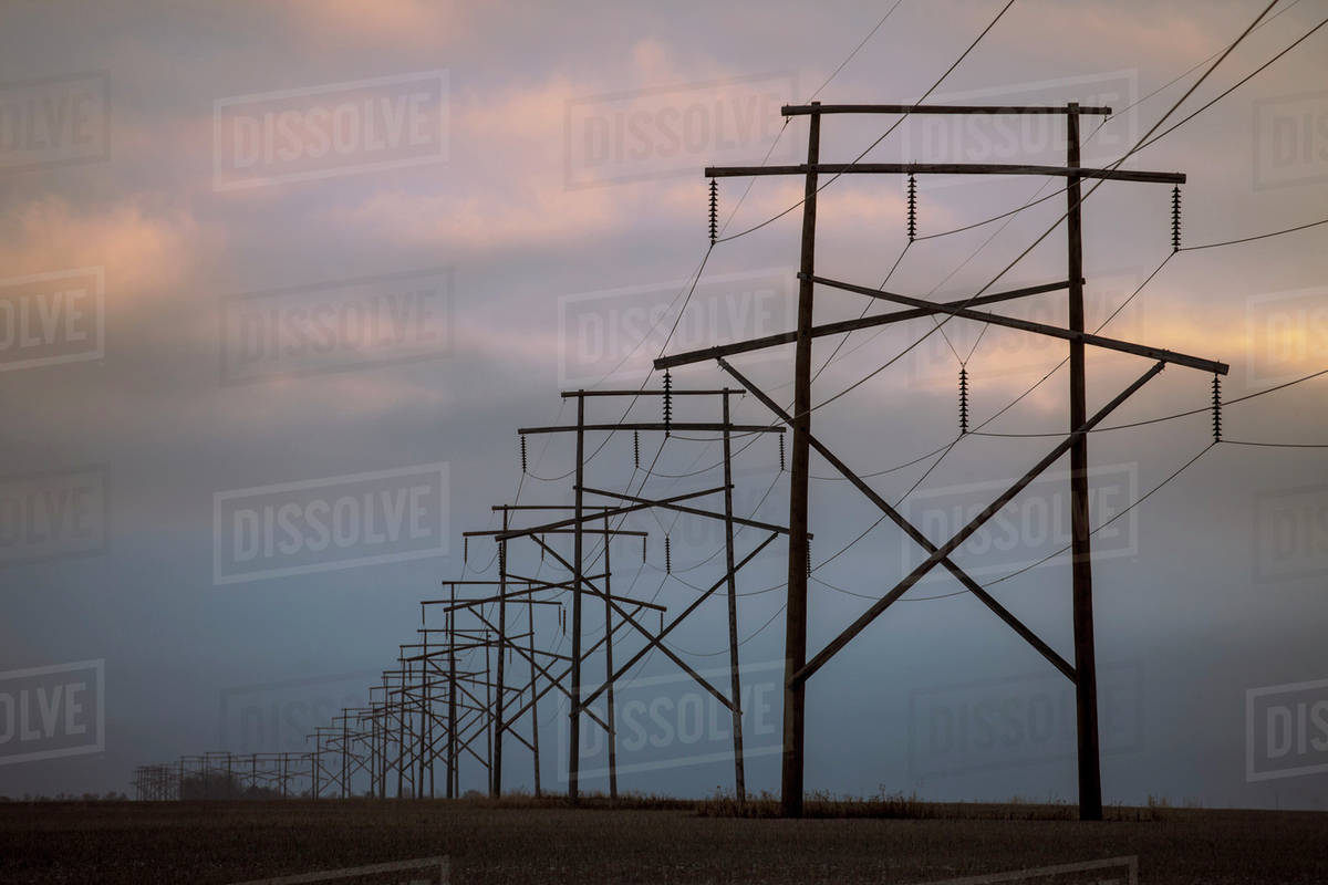 Power lines with a cloudy sky at sunset; Saskatchewan, Canada - Stock ...