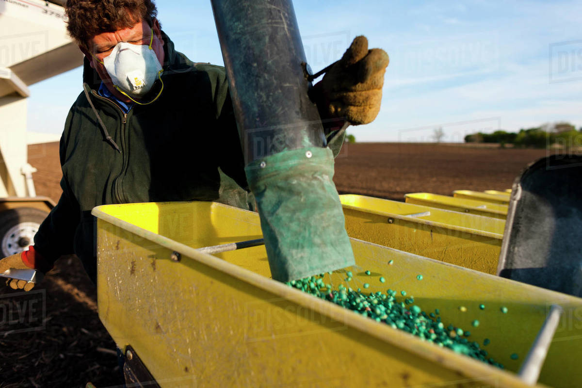 Agriculture - A farmer prepares for corn planting operations by loading ...
