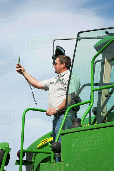 Agriculture - A sprayer operator checks wind speed to determine if it ...