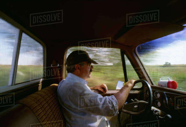 Agriculture - View from inside the cab of a farmer driving his pickup ...