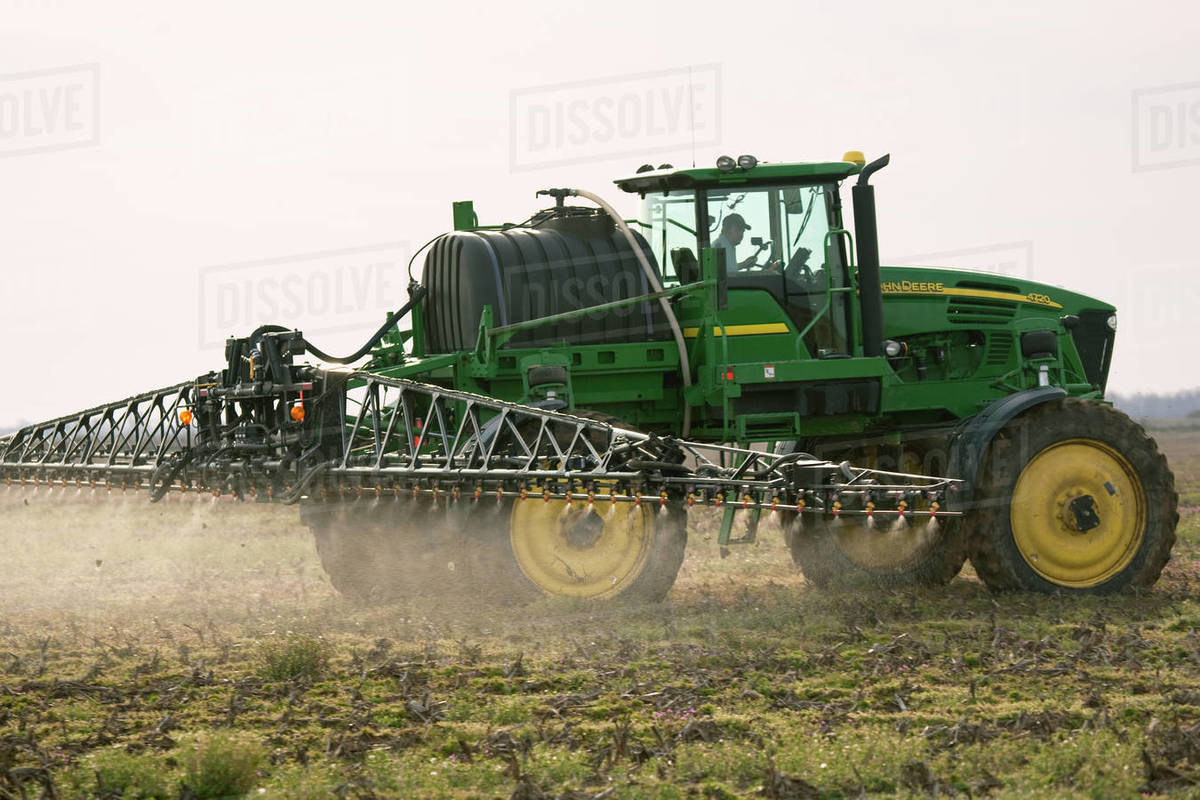 Agriculture - A John Deere sprayer applies pre-plant burndown herbicide ...