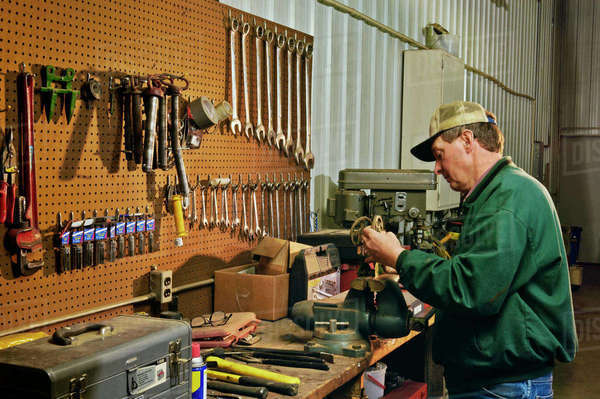 Agriculture - A farmer works on machinery in his farm workshop / Iowa ...